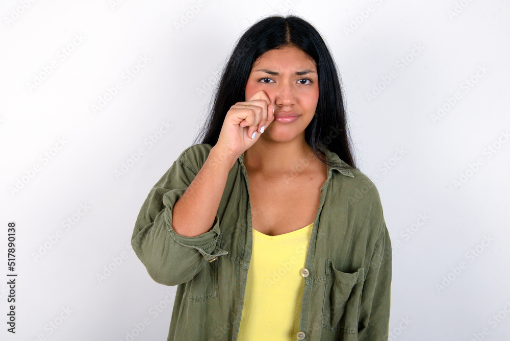 Disappointed dejected young brunette woman wearing green overshirt ...