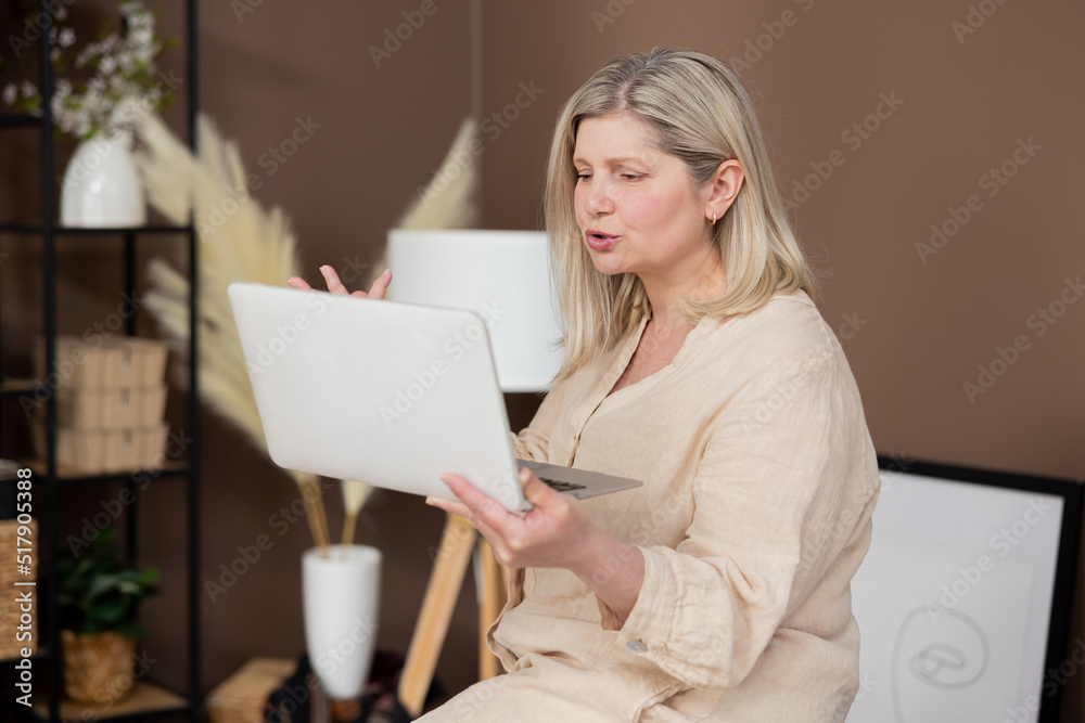 Senior woman struggling with technology, confused, stares at computer ...