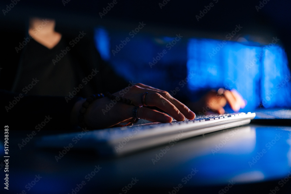 Foto de Close-up hands of unrecognizable hacker man working typing on keyboard laptop computer ...