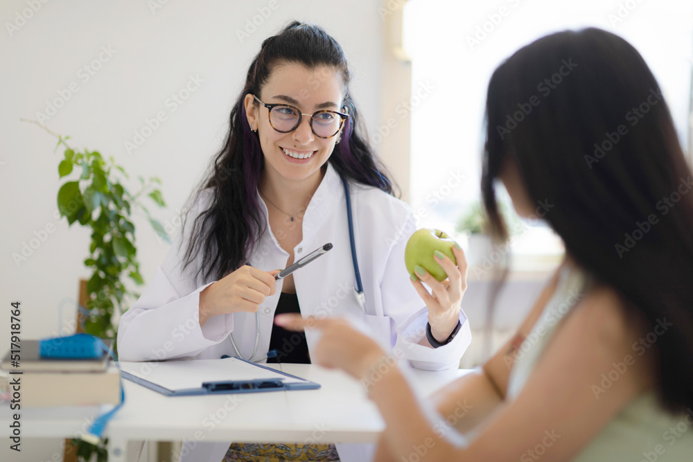 Smiling female doctor nutritionist giving consultation about diet plan ...