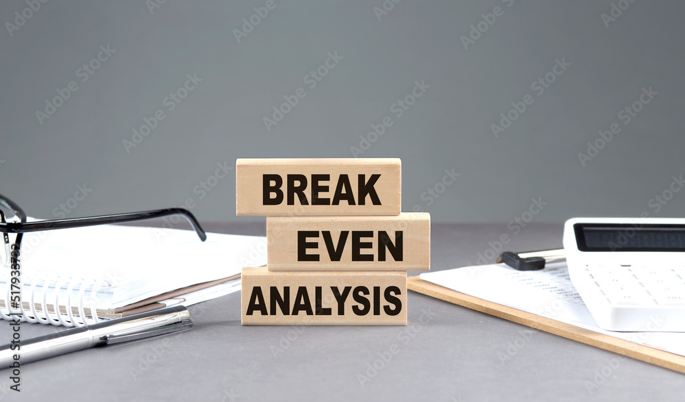 BREAK-EVEN ANALYSIS text on wooden block with notebook,chart and ...