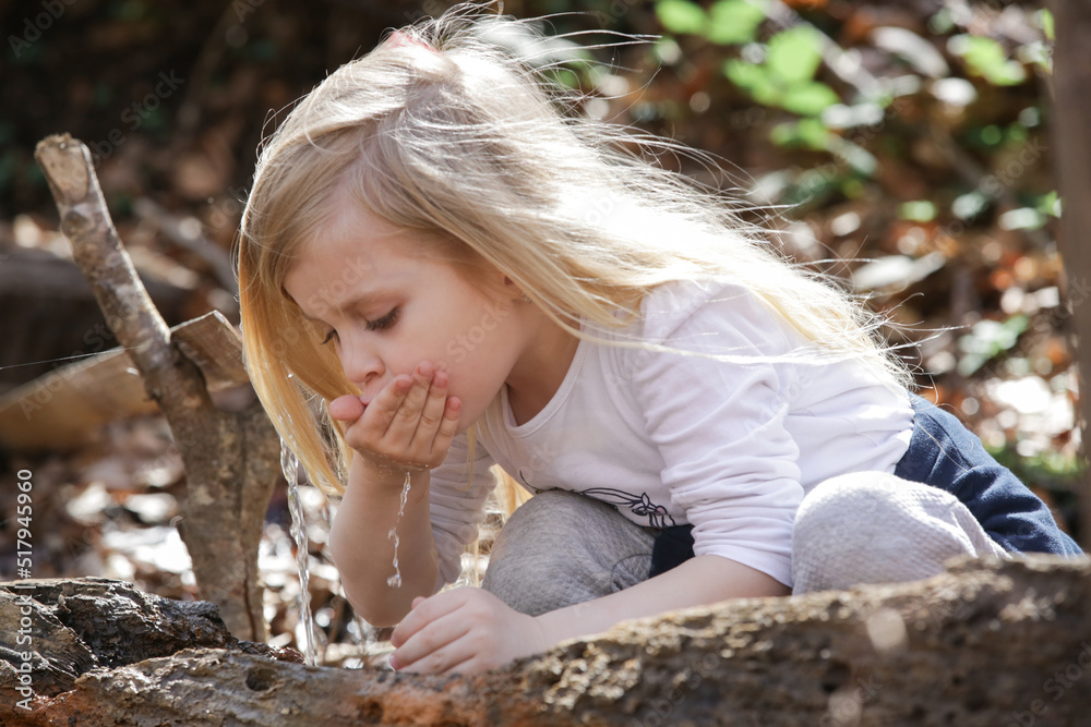 Cute little girl drinking clean spring water in the forest. Children's ...