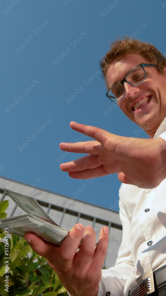 SLOW MOTION, BOTTOM UP, CLOSE UP: Businessman celebrates getting his ...