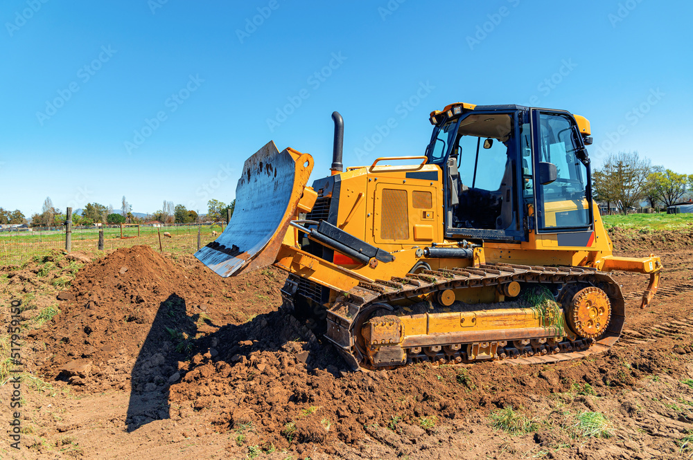 Side view working bulldozer clears the area before construction. Blue ...