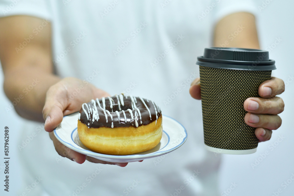 Hombre Moreno con una dona y cafe en las manos. Stock Photo | Adobe Stock