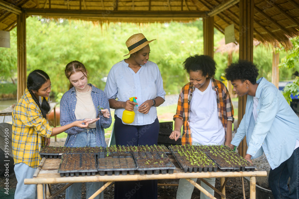 Group of mixed race students and teacher learning agriculture ...
