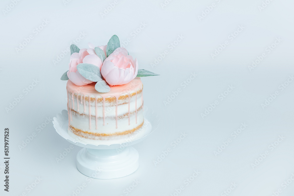 Simple white and pink miniature birthday cake with soft floral accents ...