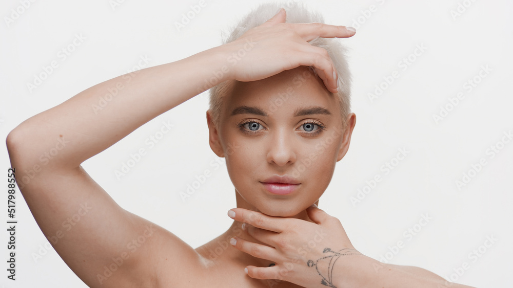 Pretty young slim Caucasian woman with short white hair touches her ...