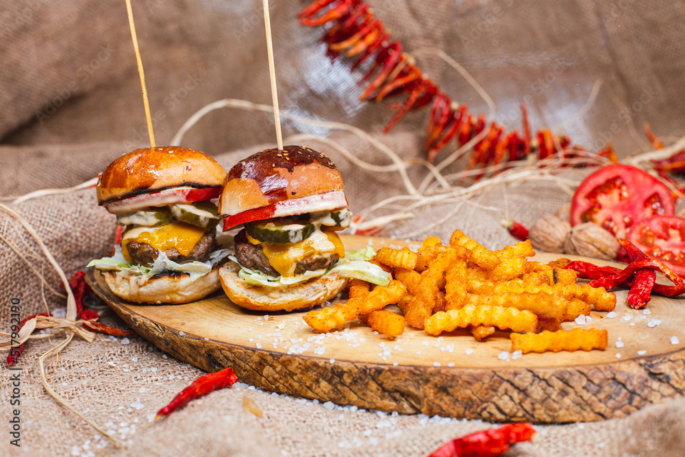 Mini burgers. Two mini hamburgers, pickled cucumbers, tomatoes, cheddar ...