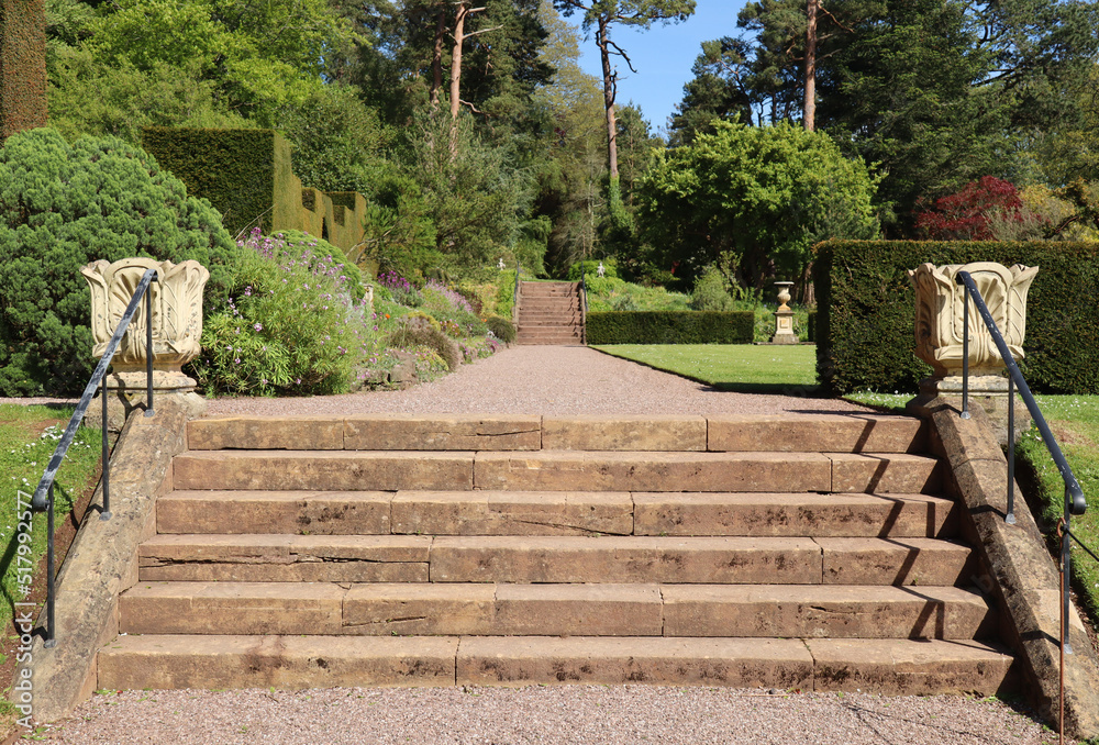 Old stone steps lead up to a gravel path and onwards to a second set of ...