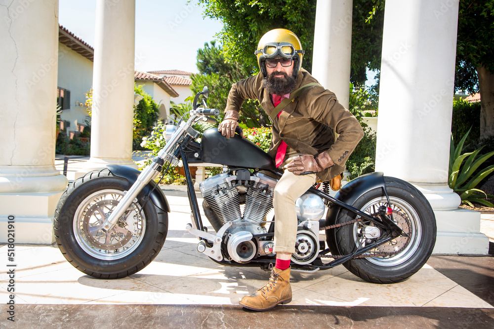 A man with a beard on a motorcycle wearing a gold helmet Stock Photo ...