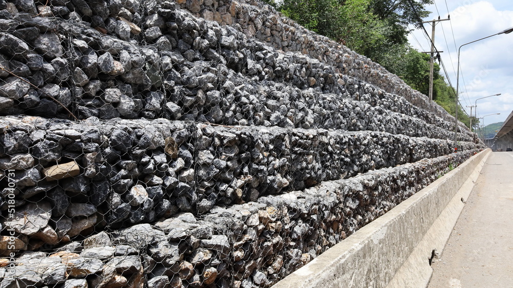 Stonewall to prevent landslides. The roadside gabion stone walls ...