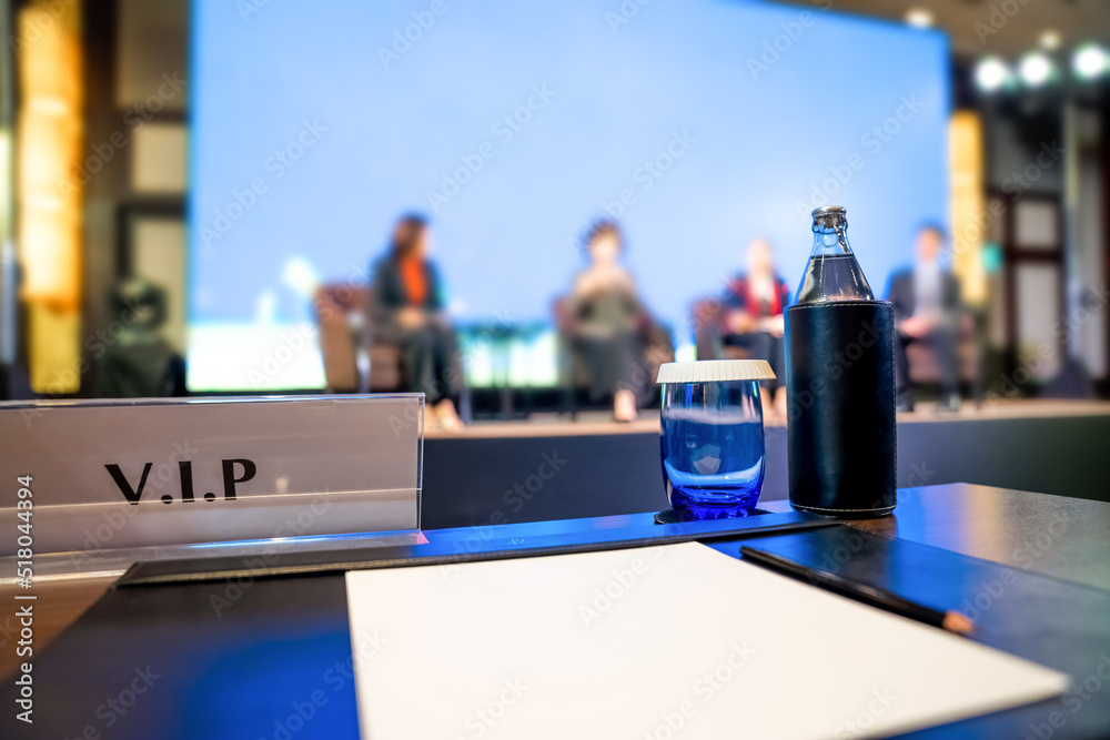 VIP seating, with plain white paper, a pencil, a glass of water, and a ...