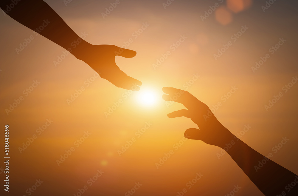 Silhouette of reaching, giving a helping hand, hope and support each other over sunset ...