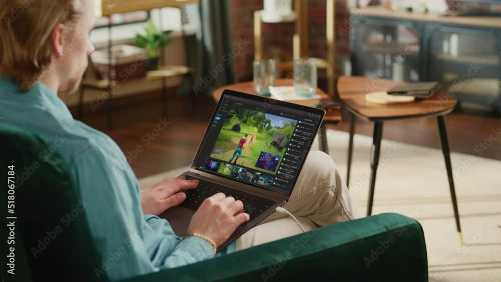 Young Man Using Laptop Computer to Watch Video Game Streaming, Writing ...