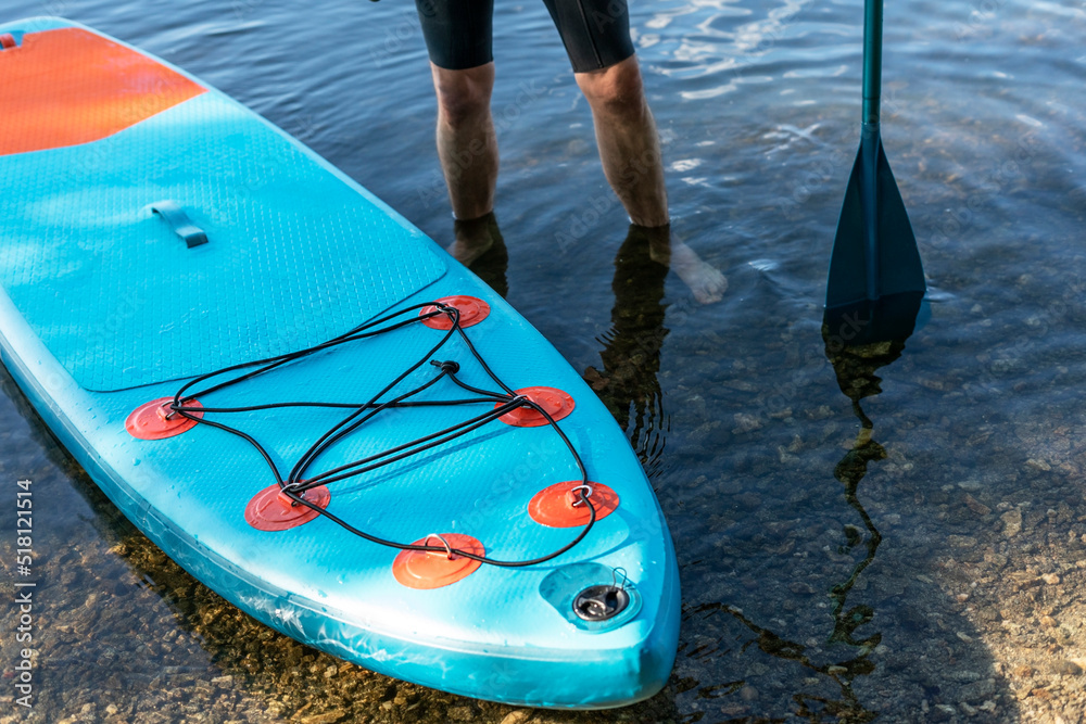 Man faceless with stand up paddleboard blue SUP on the water lake with ...