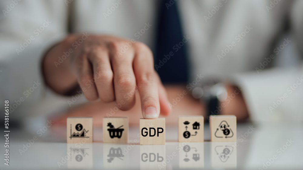 GDP, symbol of gross domestic product Businessman holding a wooden ...