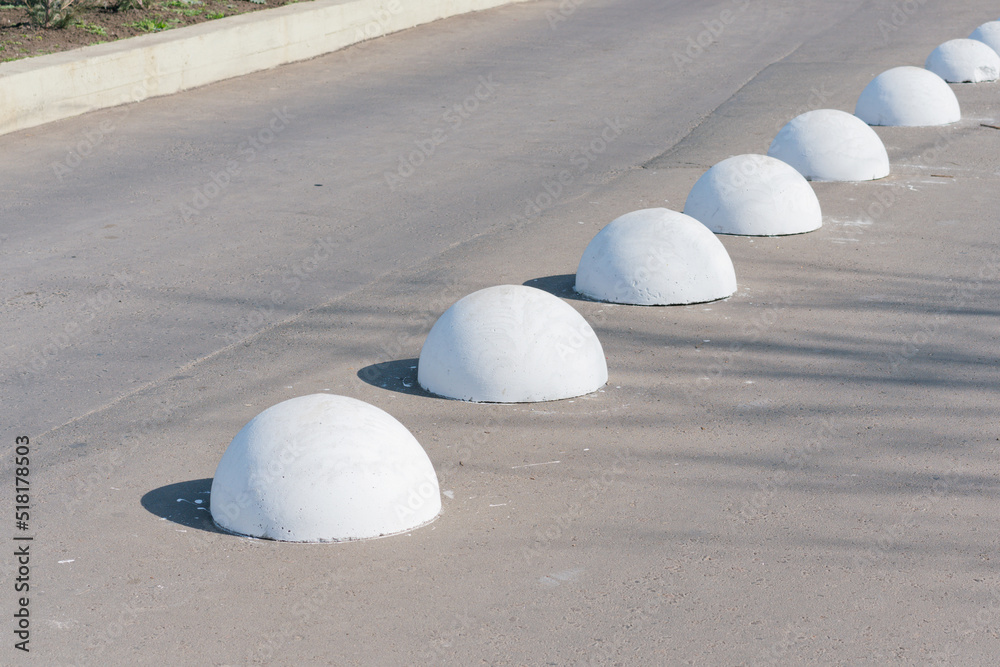 Concrete ball spheres lie down on the road. Bollards. Urban. Pavement ...