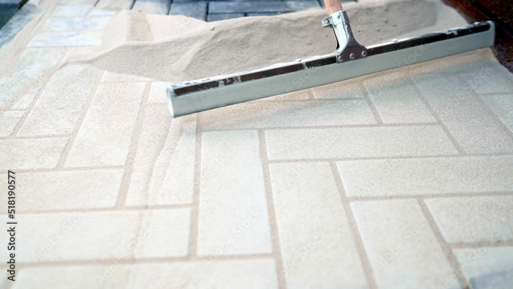 Trowel for laying floor tiles. Alignment of sand mortar on paving ...