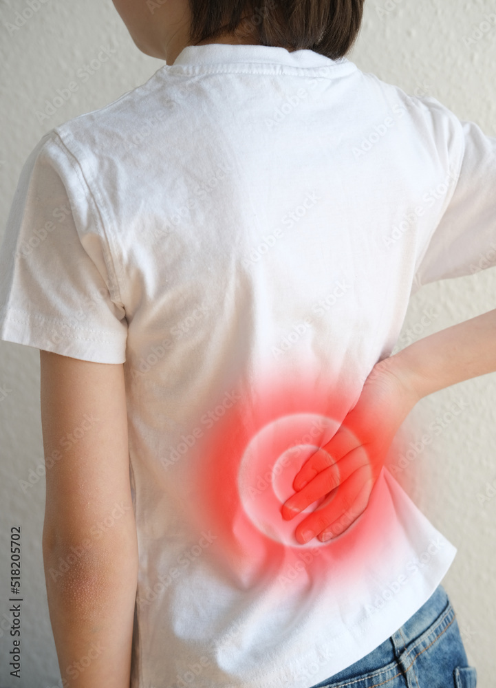 back of boy, child 8-10 years old in a white t-shirt grabbed a sore ...