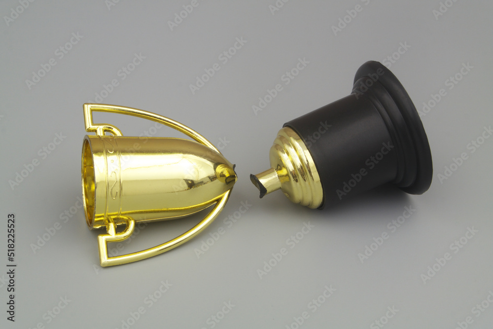 Broken golden trophy cup on gray background. Stock Photo | Adobe Stock