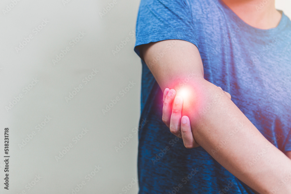 Man suffering from elbow pain standing on white background, health ...