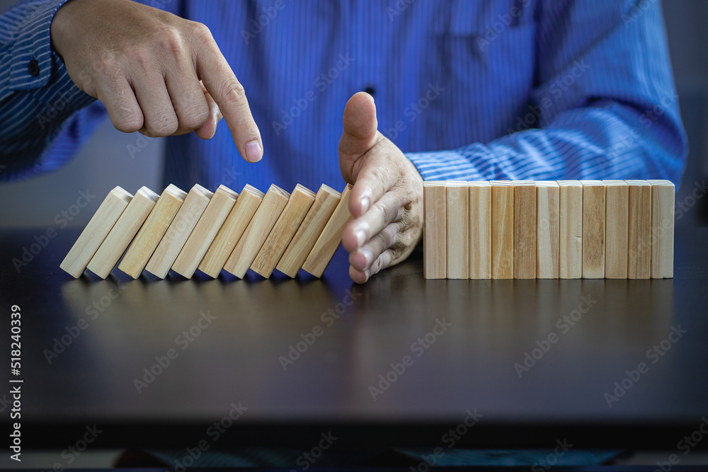 Business Risks and Strategies hand stop falling wooden block domino ...