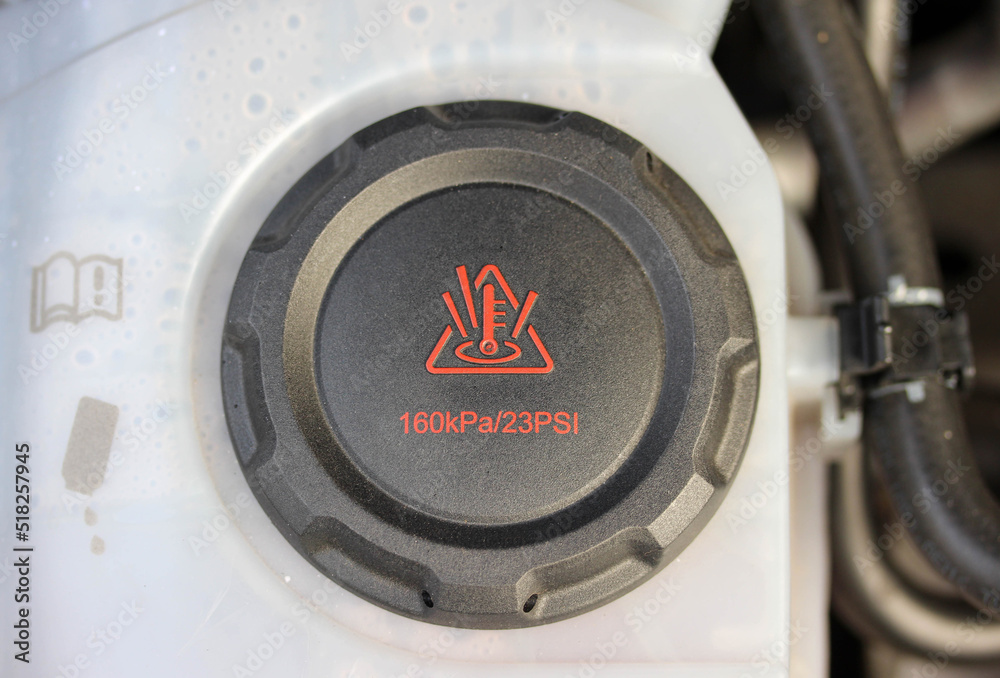 Pressure and heat warning icon on the cap of a new car radiator tank ...