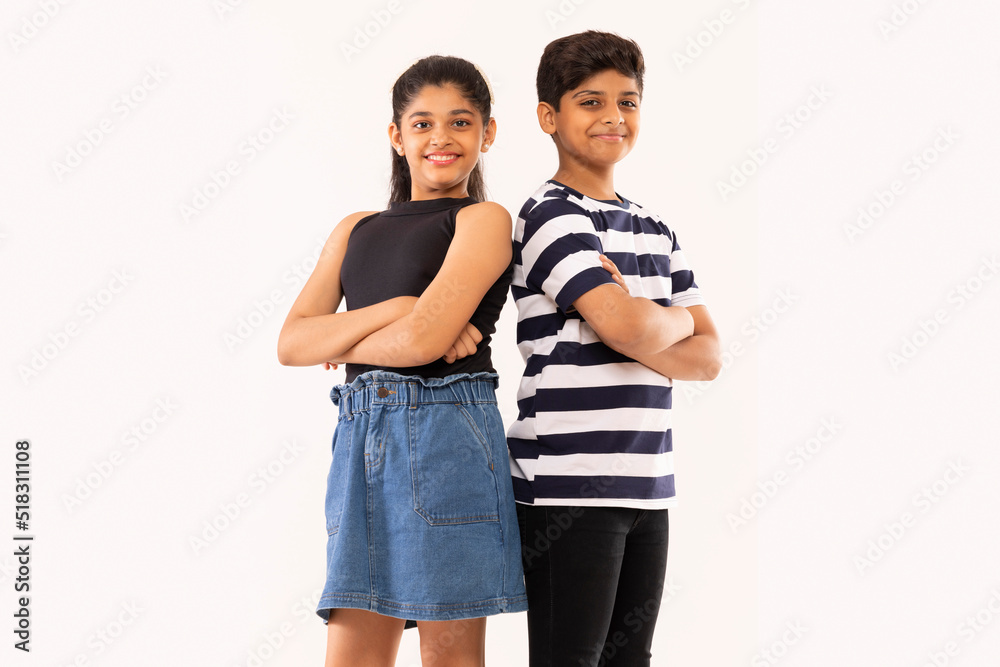 Cheerful boy and girl standing back to back with crossed arms Stock ...