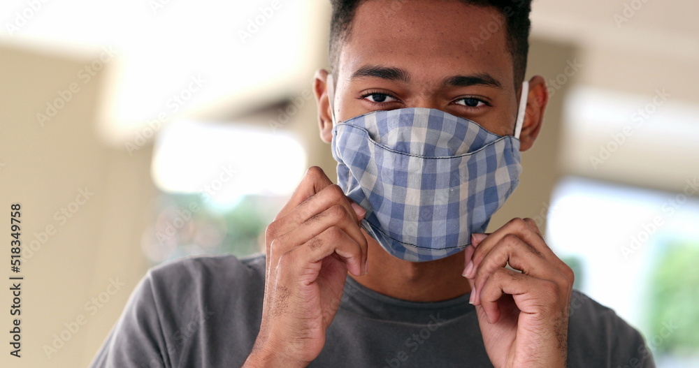 Young man putting covid-19 face mask. Black African ethnicity wears ... Young man putting covid-19 face mask. Black African ethnicity wears ...