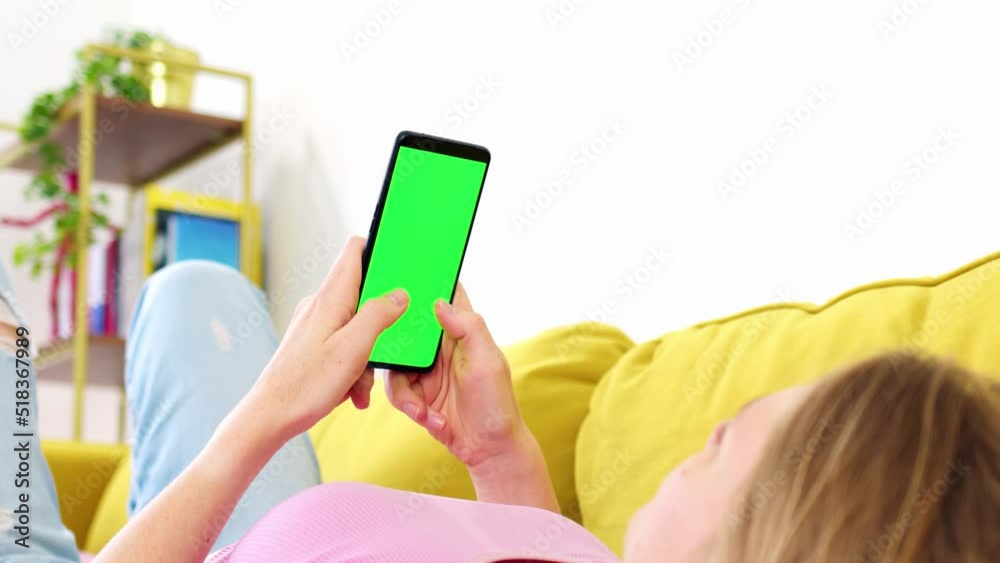 phone with green screen chroma key in hands of blonde in pink top ...