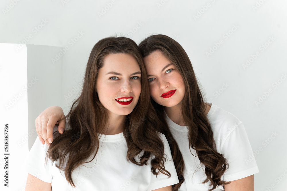 Two beautiful women twin sisters posing white background Stock Photo ...