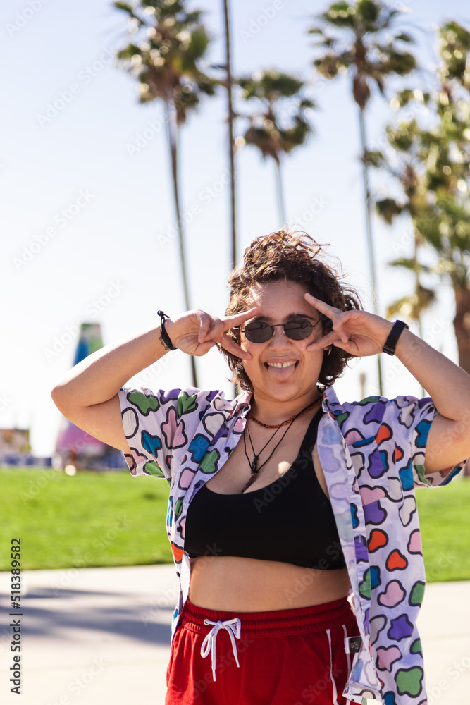Stylish non-binary person making faces and smiling outside. Stock Photo ...
