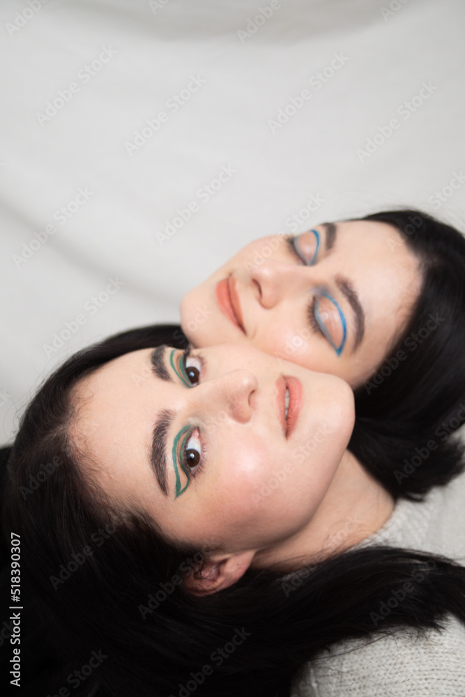 twin sisters laying shoulder to shoulder on white backdrop Stock Photo ...