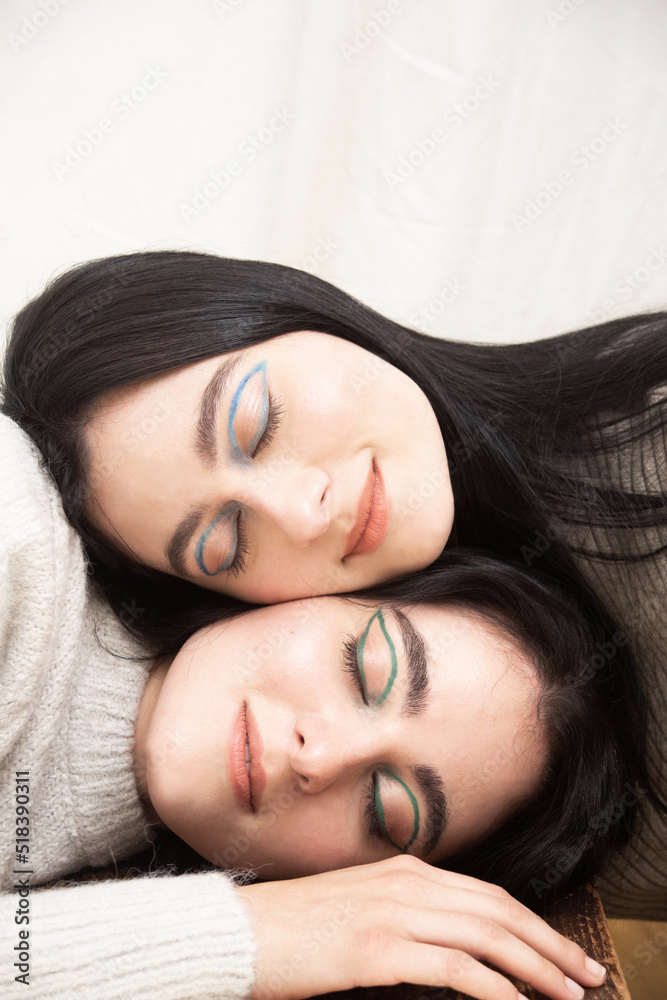 twin sisters laying shoulder to shoulder on white backdrop Stock Photo ...