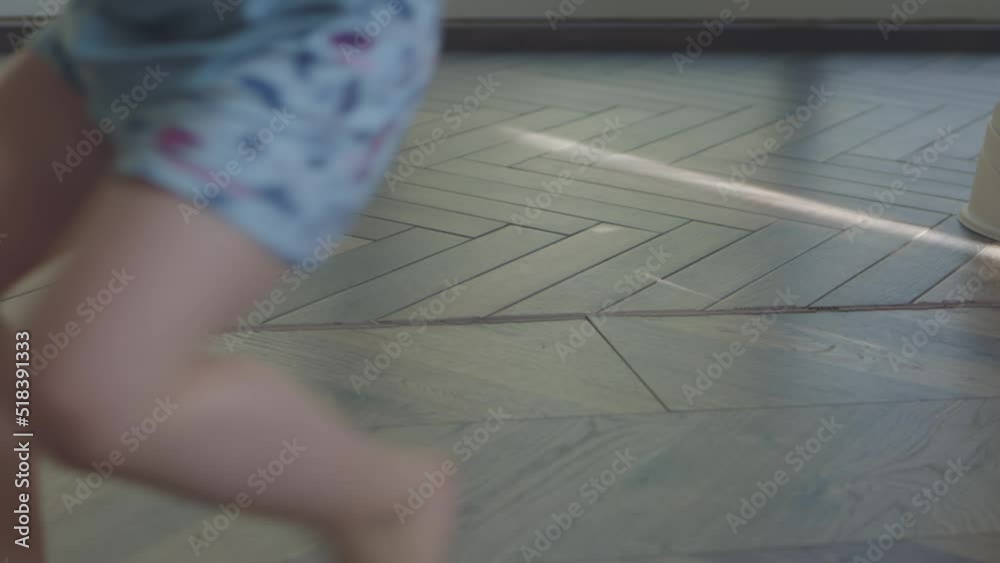 barefoot boy child falling down on wooden floor at home room. kid fall ...