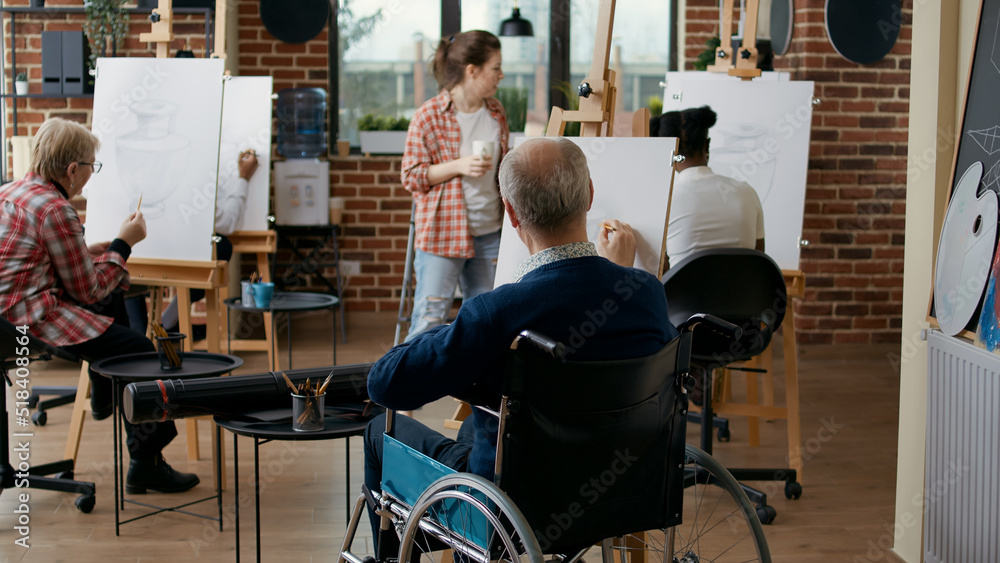 Old man with disability using pencil to draw masterpiece in art class ...