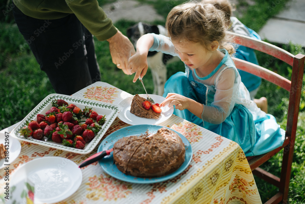 Little kid eating cake outdoors Stock Photo | Adobe Stock