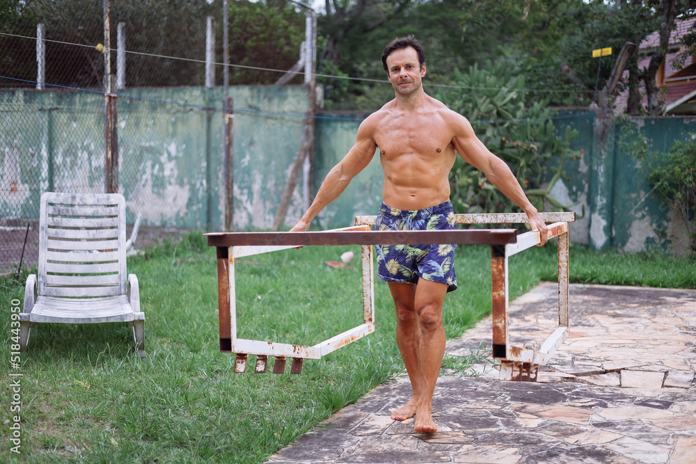 Bodybuilder hold a metal structure and walks on stone flooring Stock ...