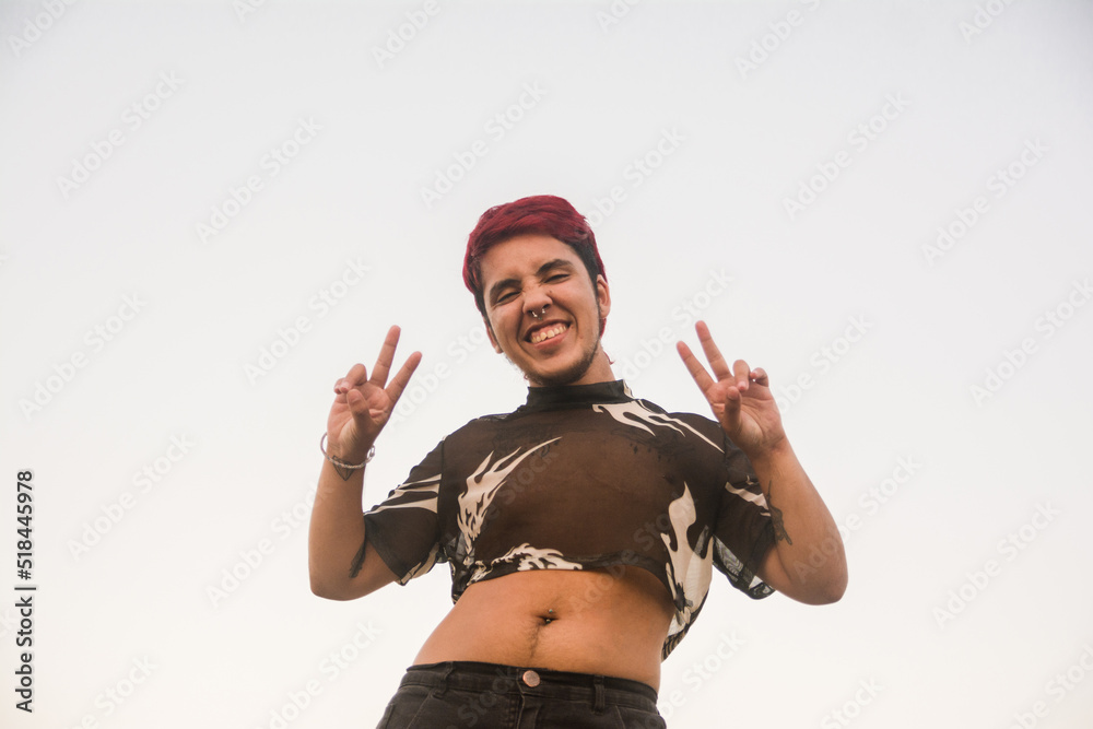 Laughing trans man giving peace sign with joy and attitude Stock Photo ...