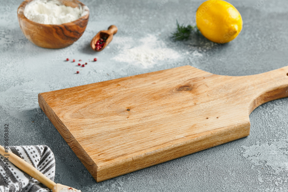 Food mockup. Empty wooden board on concrete table with cooking ...