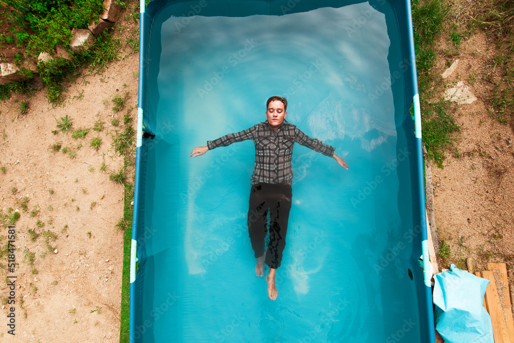 Relaxed dressed man floating in plastic pool Stock Photo | Adobe Stock