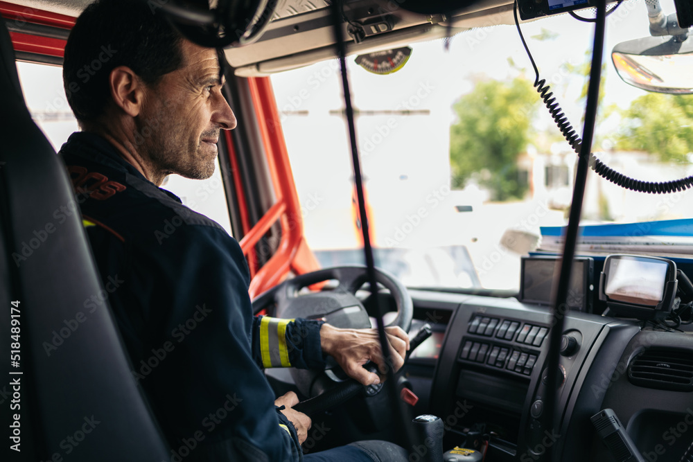 Firefighter driving the fire truck Stock Photo | Adobe Stock