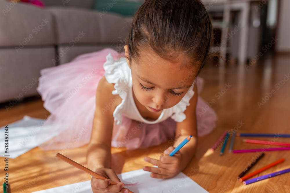 little girl dressed as a ballerina coloring a drawing at home Stock ...
