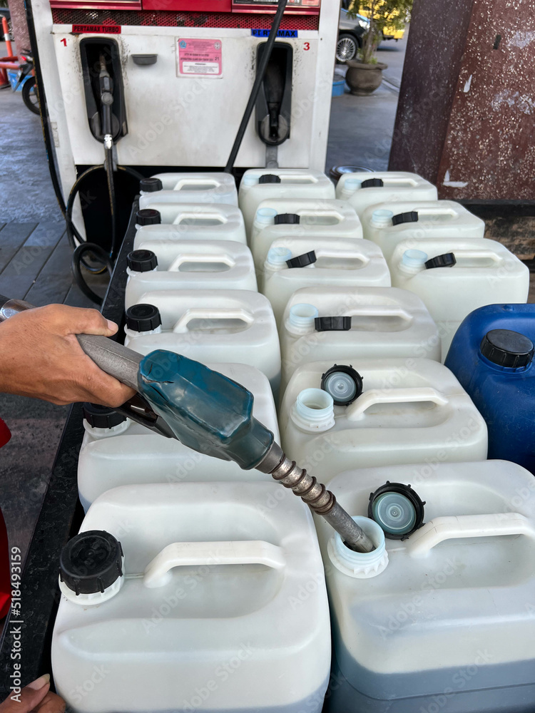Man filling gas fuel to plastic canisters at gas station can Stock ...