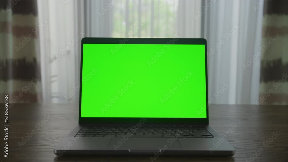 Slow optical zoom in into a laptop computer with green screen chroma ...