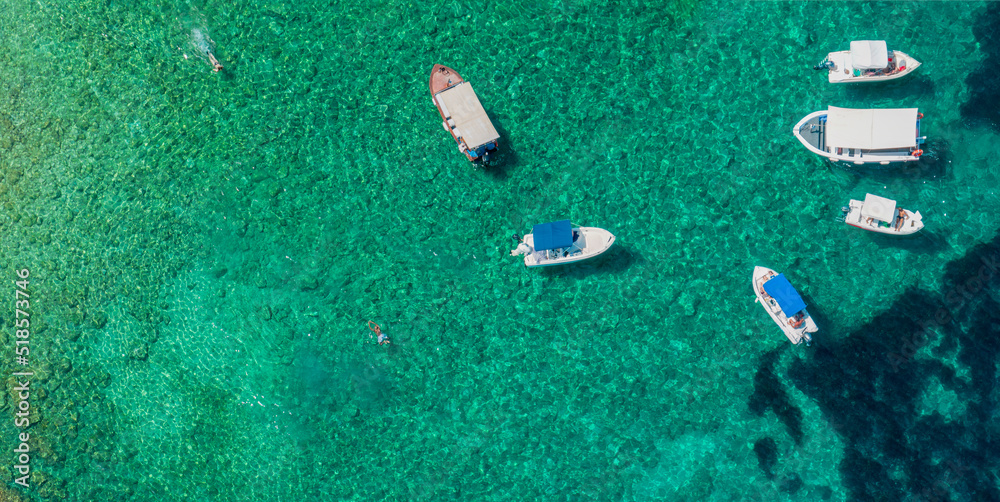 Aerial view of floating boats moored on a transparent sea. Relax on the ...