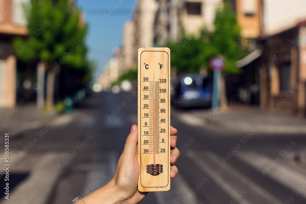 Hot weather. Thermometer in front of an urban scene during heatwave ...