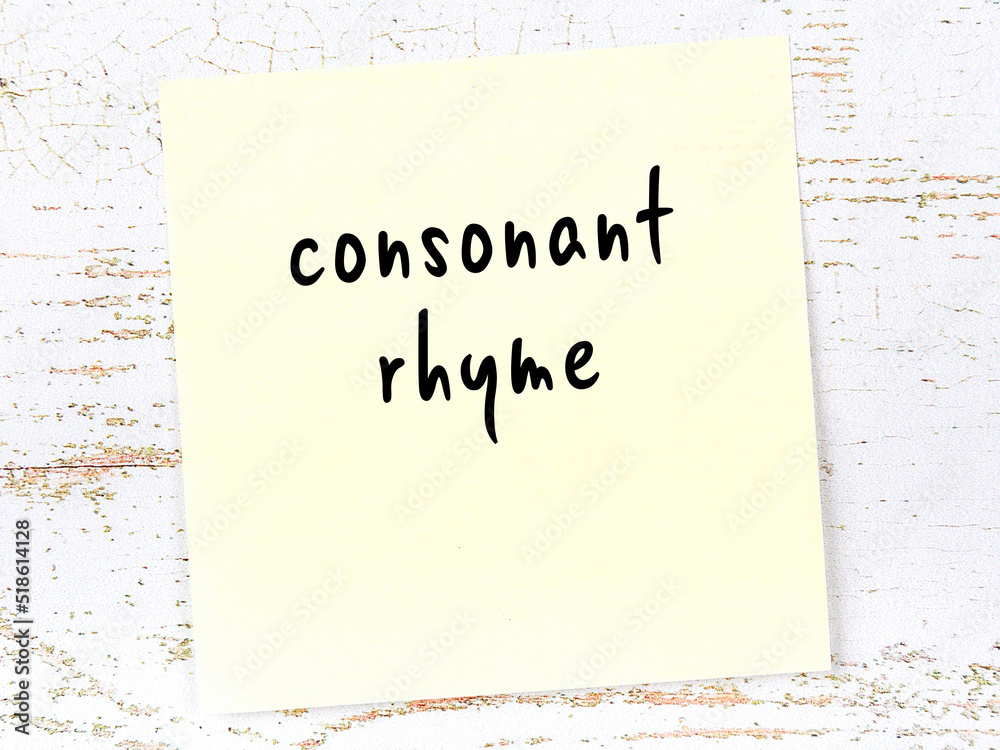 Yellow sticky note on wooden wall with handwritten word consonant rhyme ...