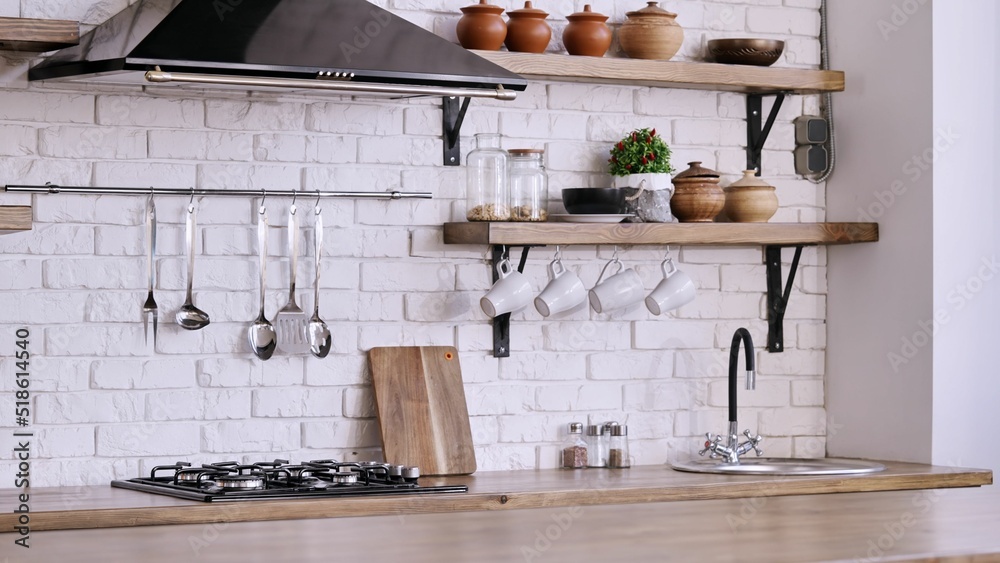 Interior design of cozy kitchen with white brick wall and range hod ...